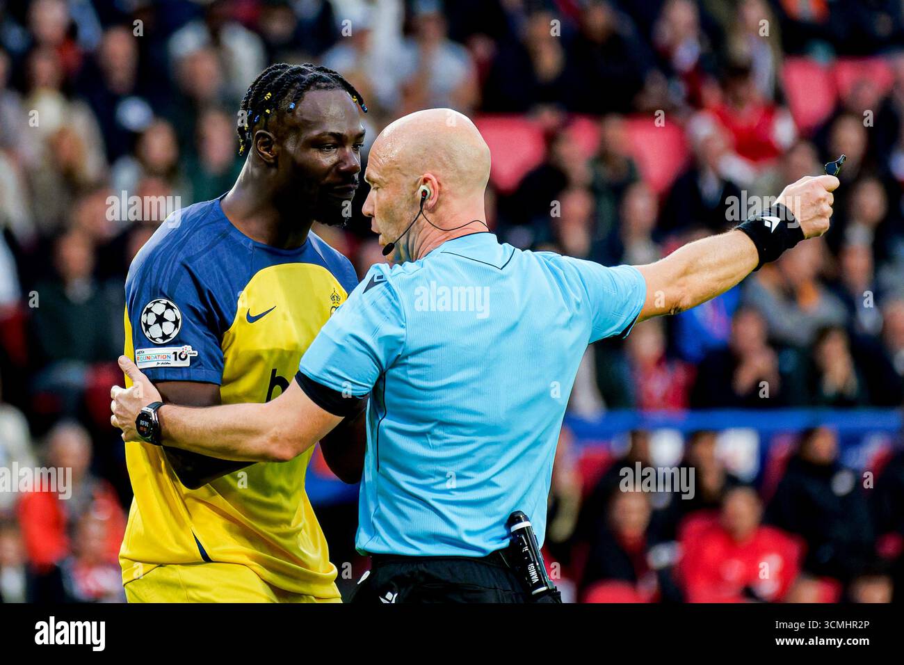 Referee Anthony Taylor is in discussion with Promise David of Royale ...