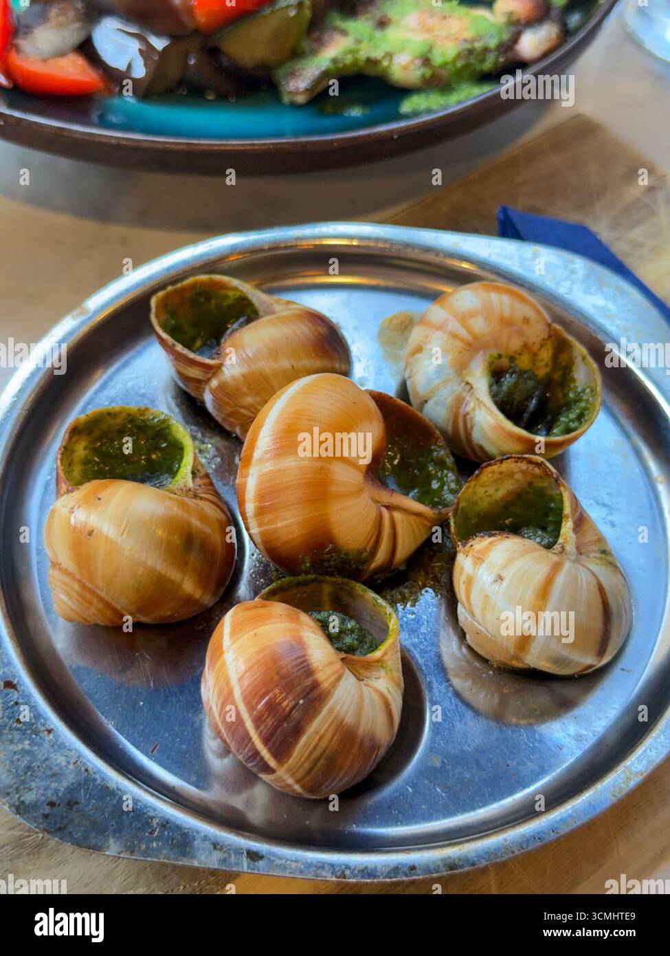 Snails with pesto sauce in a French restaurant. French national cuisine ...
