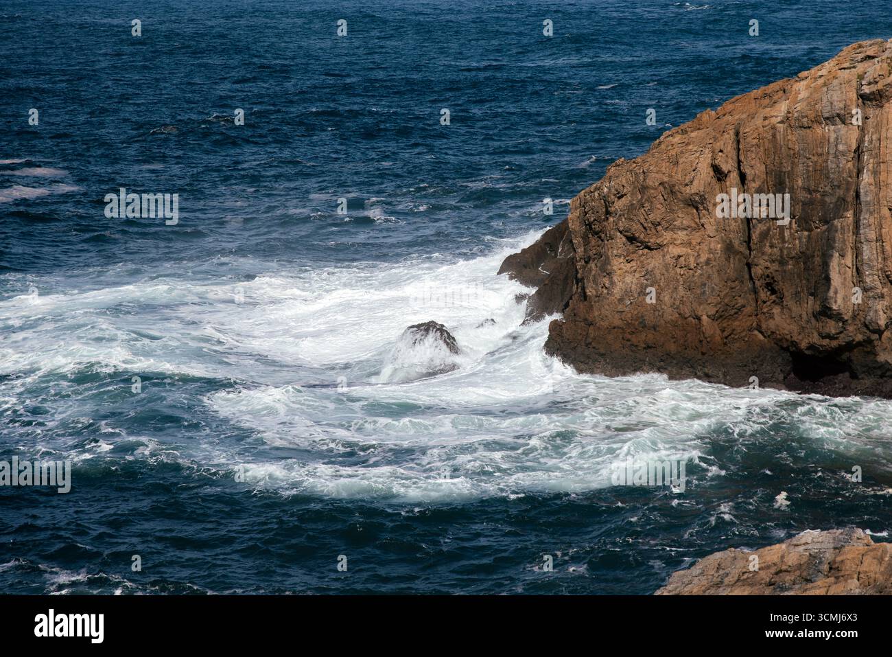 Waves crash against rugged cliffs, creating a vibrant seascape with ...