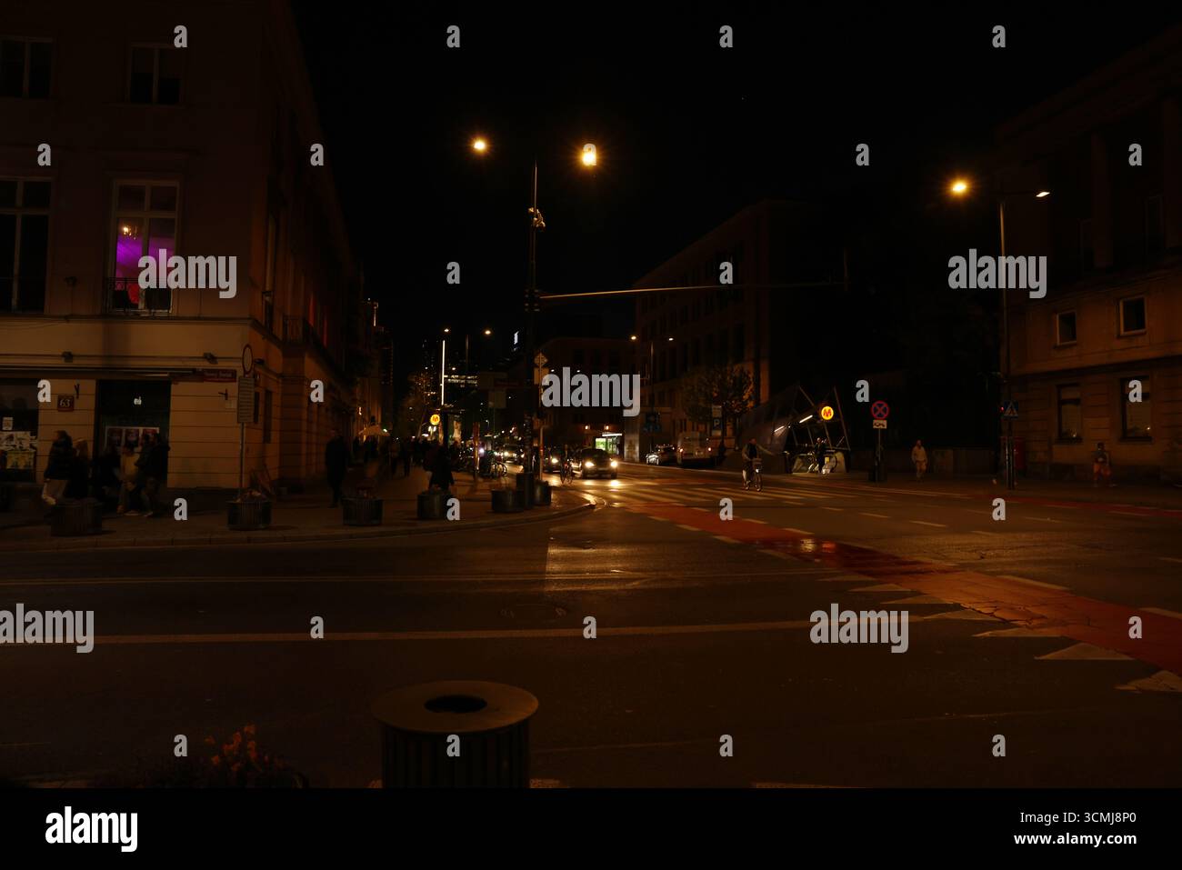 Nighttime city street scene; dimly lit buildings, sparse pedestrian ...