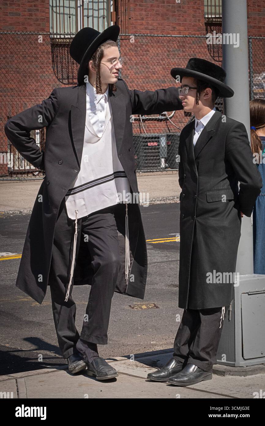 2 orthodox Jewish boys with long curled peyus have a friendly lively ...