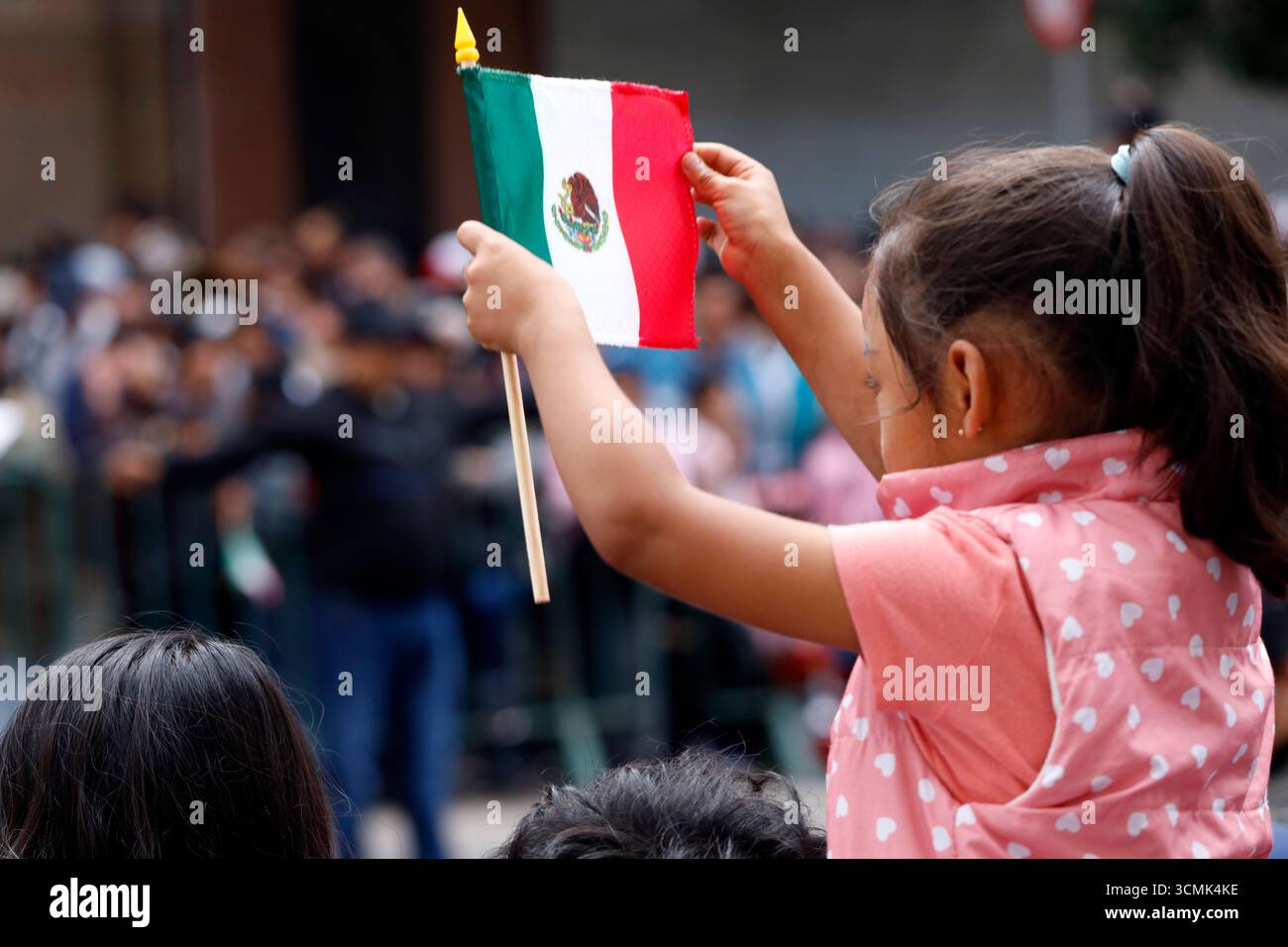 A child holds a Mexican flag during the military parade for the 215th ...