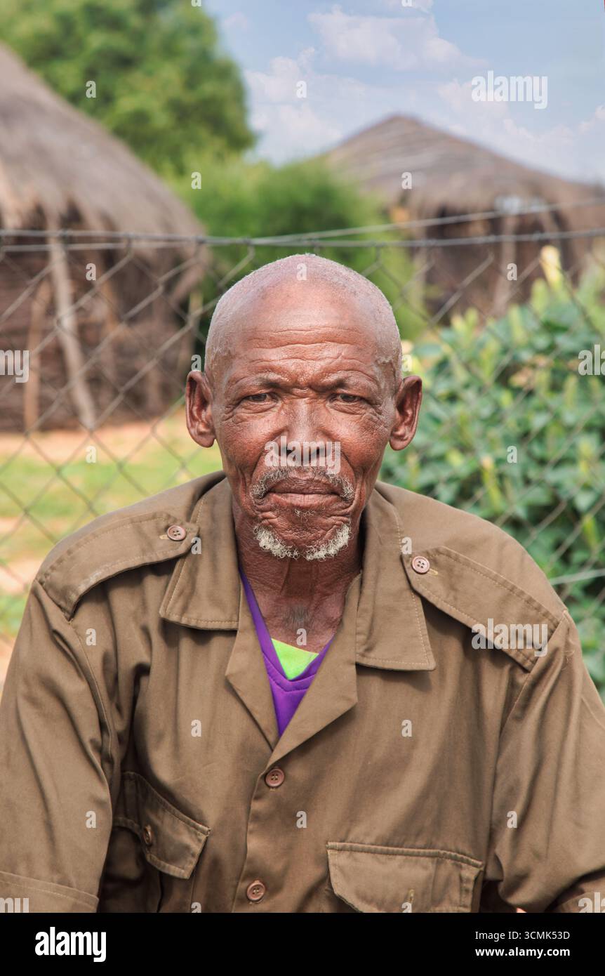 village rural ,portrait of old african man, in front of a house with ...