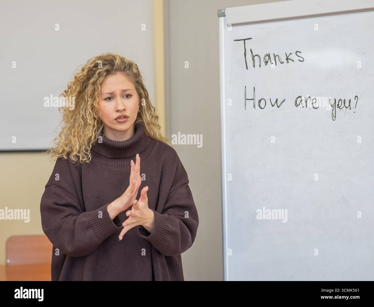 Caucasian female teacher communicates in Russian sign language with ...