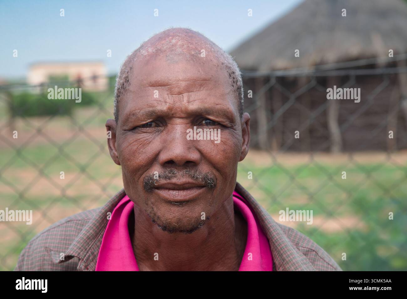 african village senior old african man, outside in front of house ...