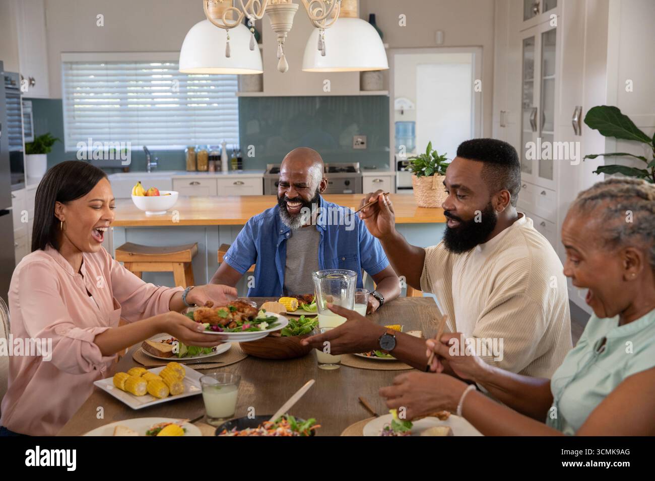 Diverse family passing plates serving hi-res stock photography and ...