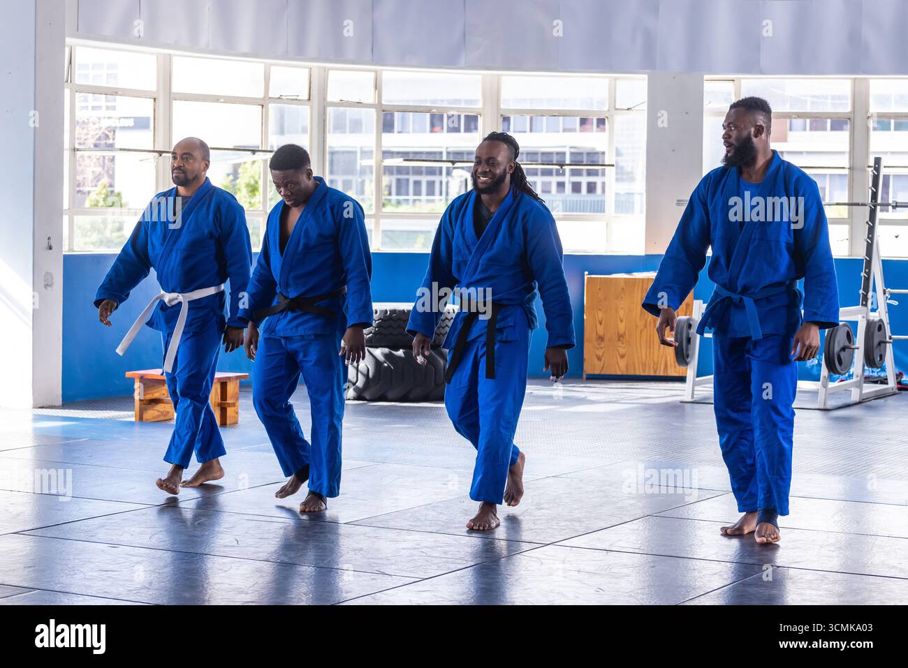 African american male martial artists walking barefoot across mat in ...