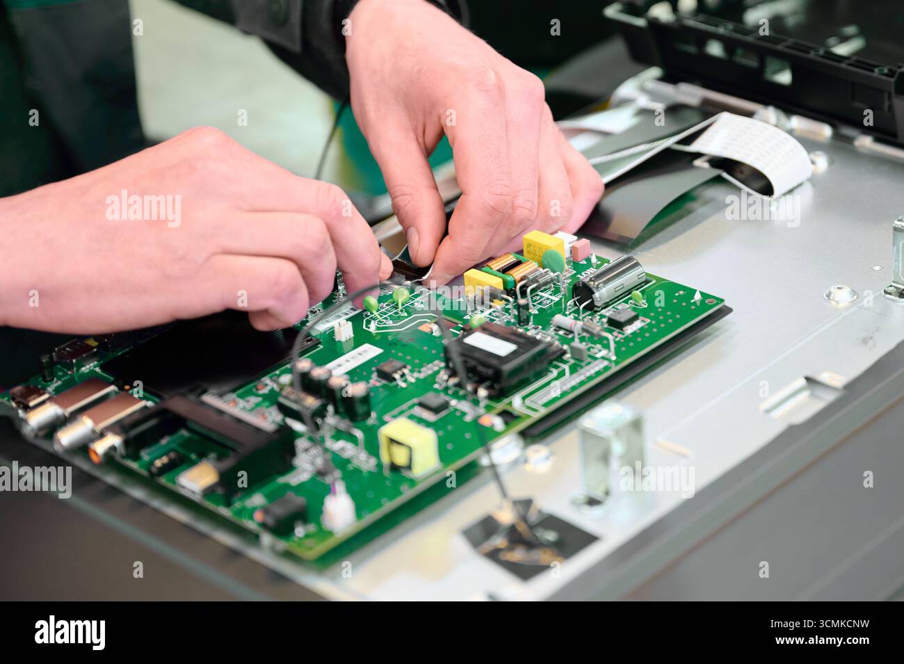 Installation of flex cables and connectors at a TV assembly plant ...