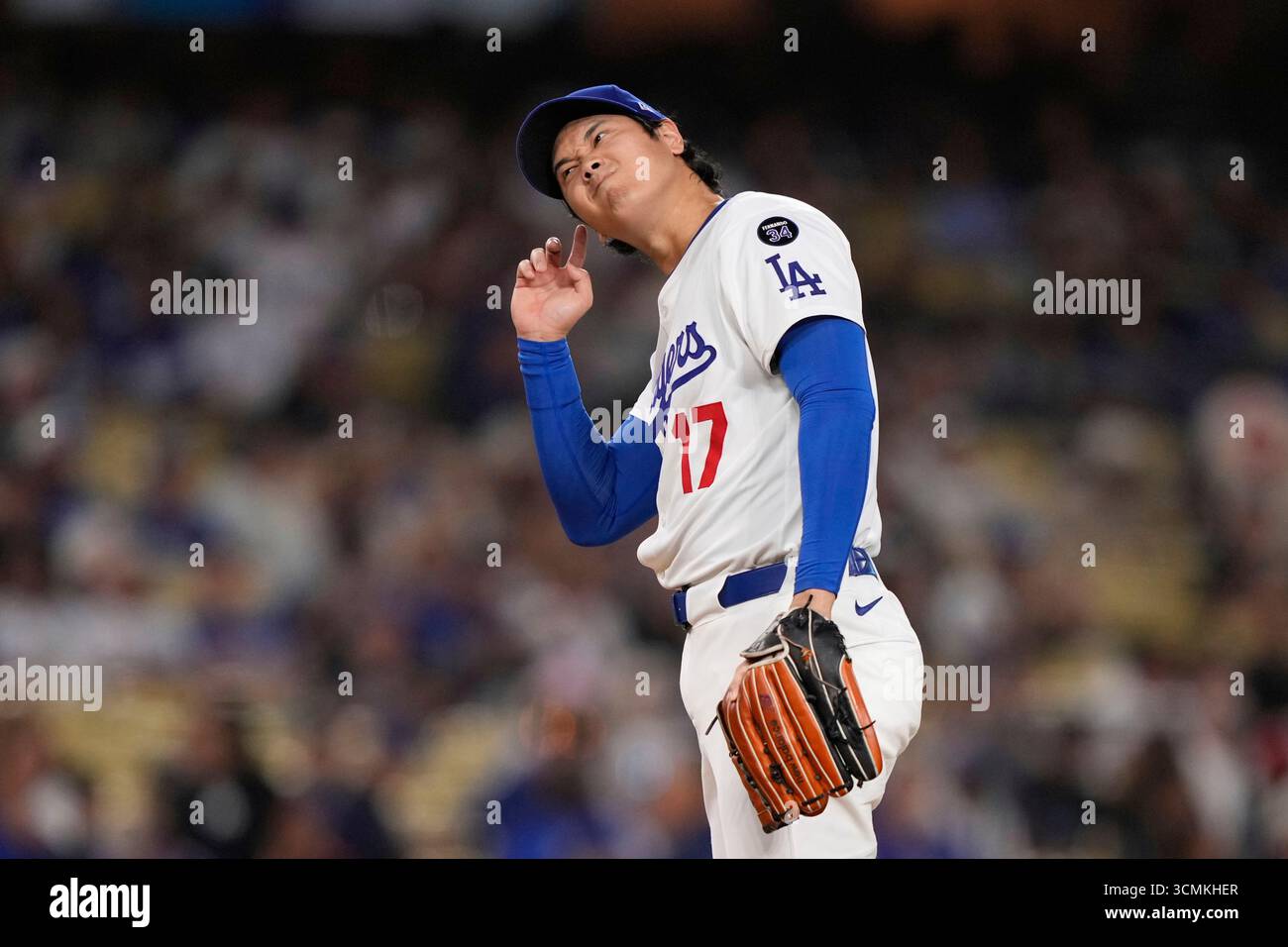 Los Angeles Dodgers starting pitcher Shohei Ohtani touches his ear as ...