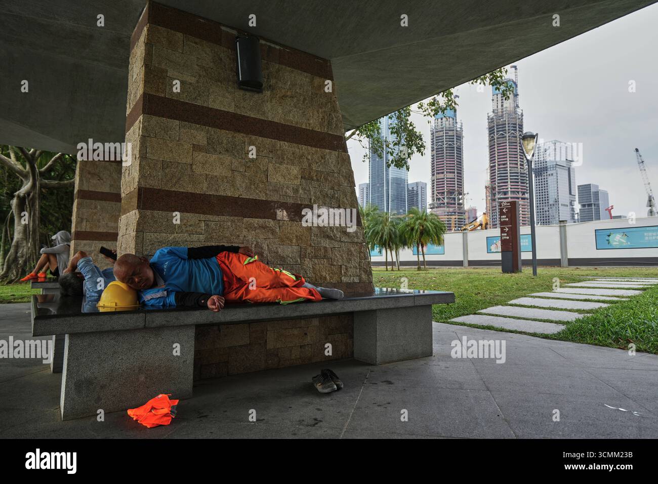 Workers take nap on the bench of a public park during a lunch break ...