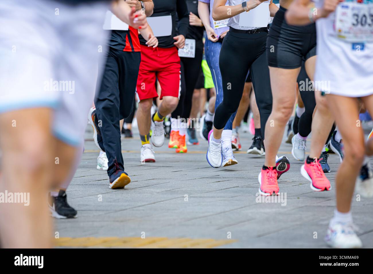 Large group of runners, athletes run in a street marathon competition ...