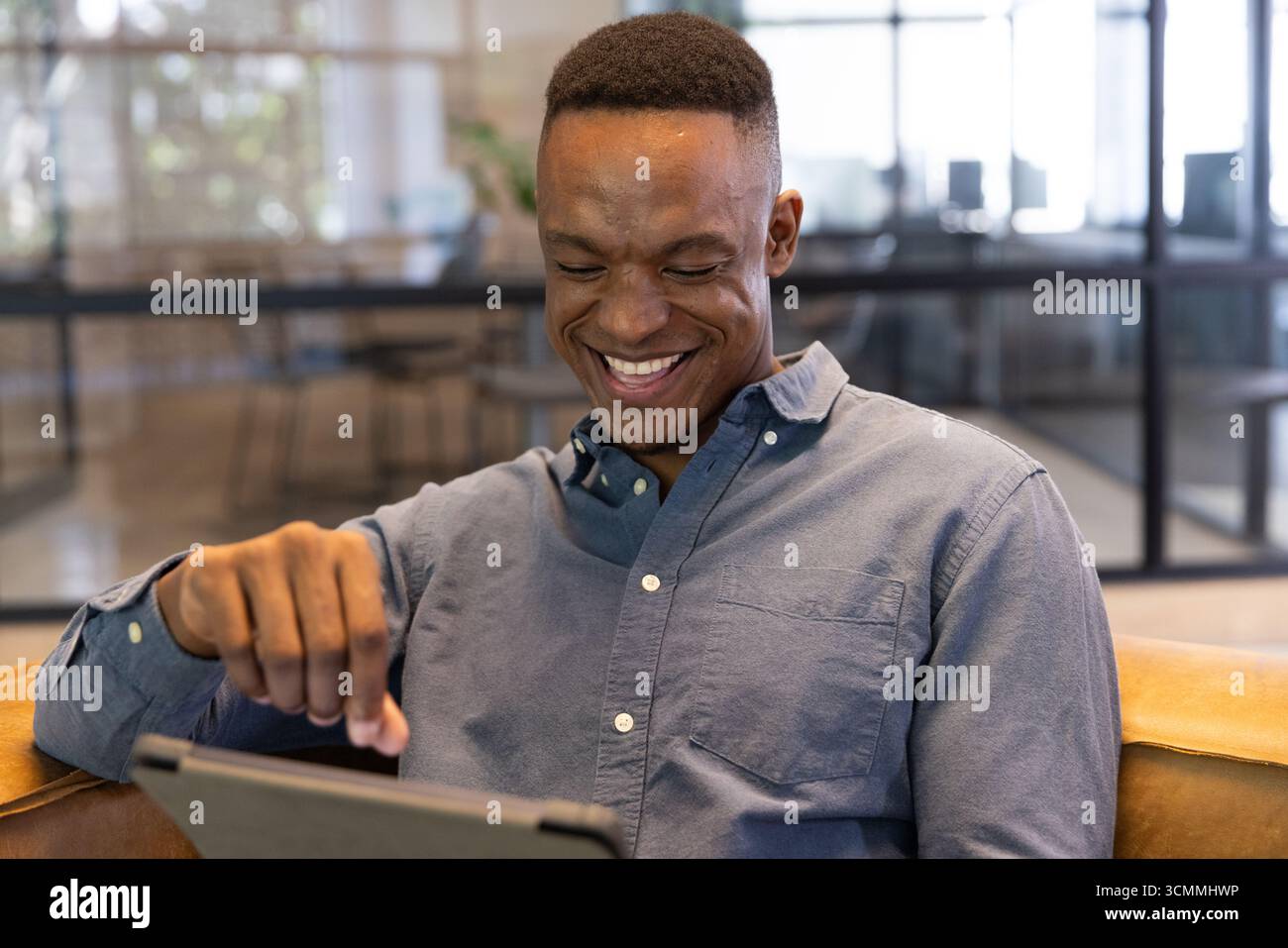 Man tapping tablet on sofa hi-res stock photography and images - Alamy