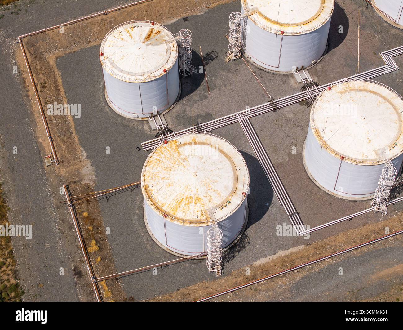 Aerial view captures four white industrial fuel storage tanks ...