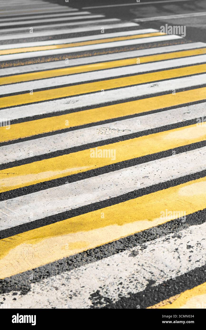 yellow White road markings indicating pedestrian crossing on asphalt ...