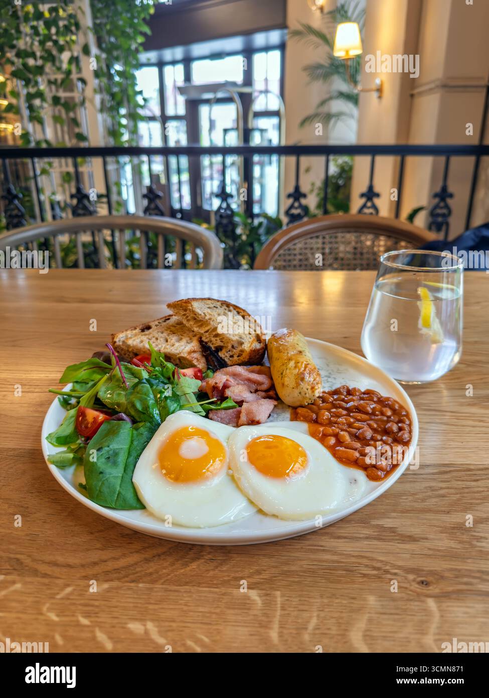 Traditional English breakfast with fried eggs, bacon, beans, sausage ...