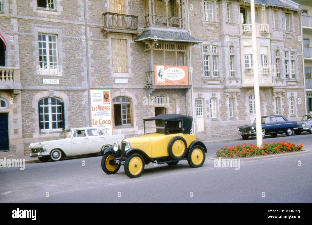 A vintage Citroën Type C parked beside an Opel Rekord outside a stone ...