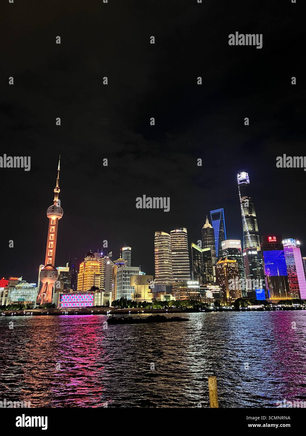 Illuminated Shanghai skyline at night with Oriental Pearl Tower in red ...