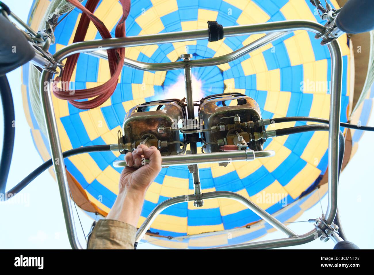 Man operating hot air balloon burner system from below, hand gripping ...