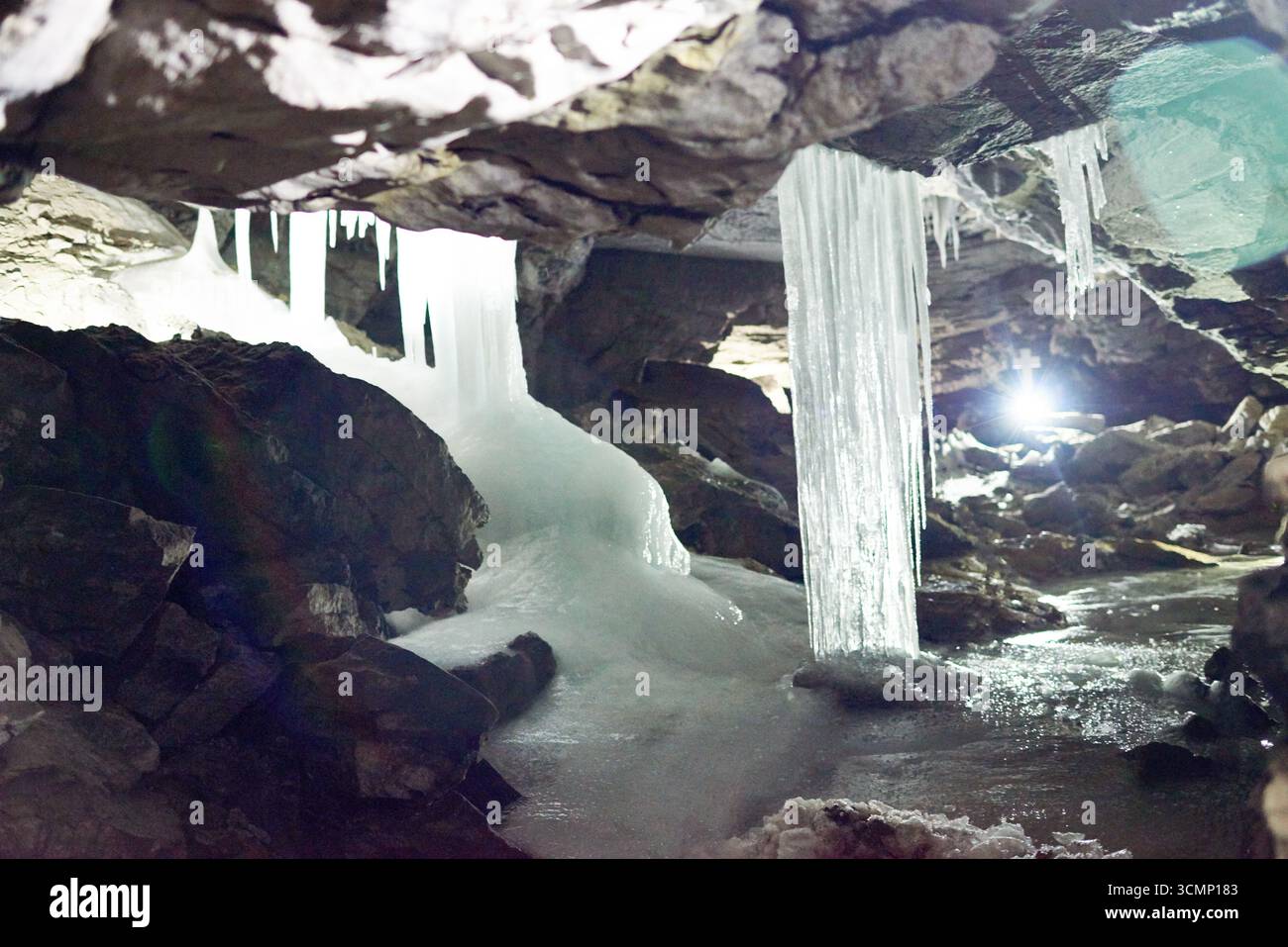 Ice formations hanging from rocky cave ceiling with frozen stalactites ...