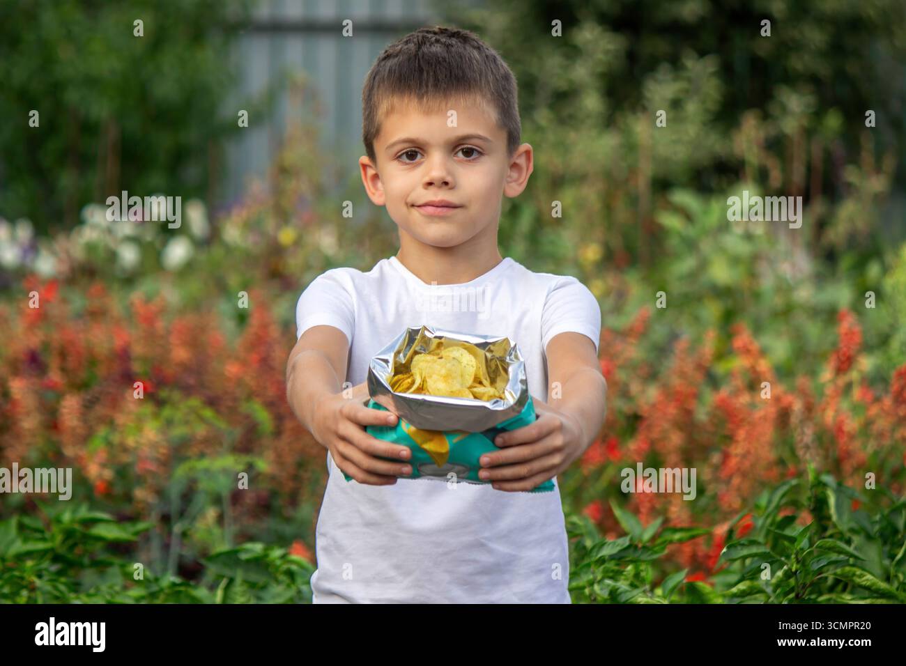 Boy eating chips from a pack. Unhealthy food concept Stock Photo - Alamy