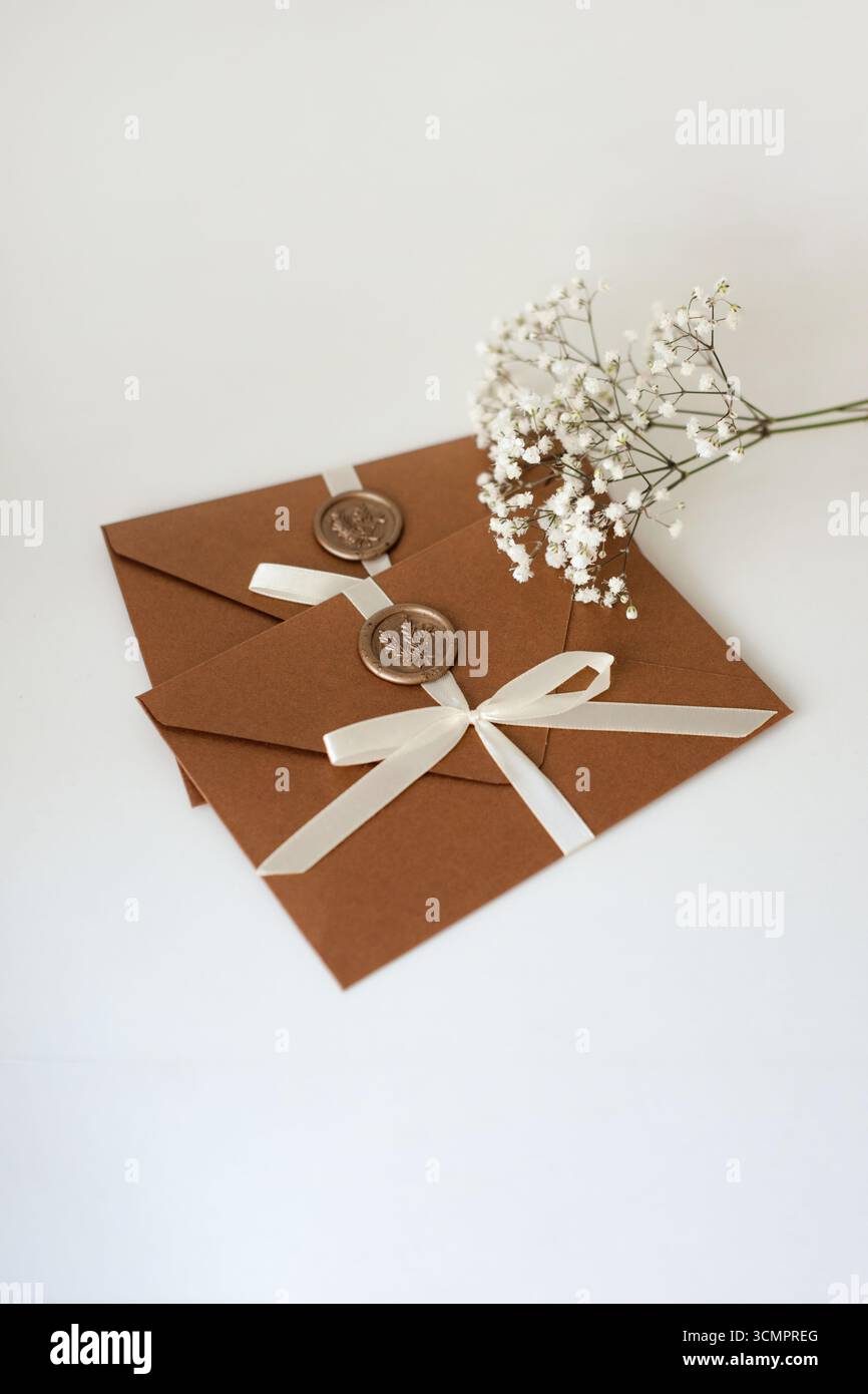 two Gift Certificate Bronze envelope with bow and flowers on white ...