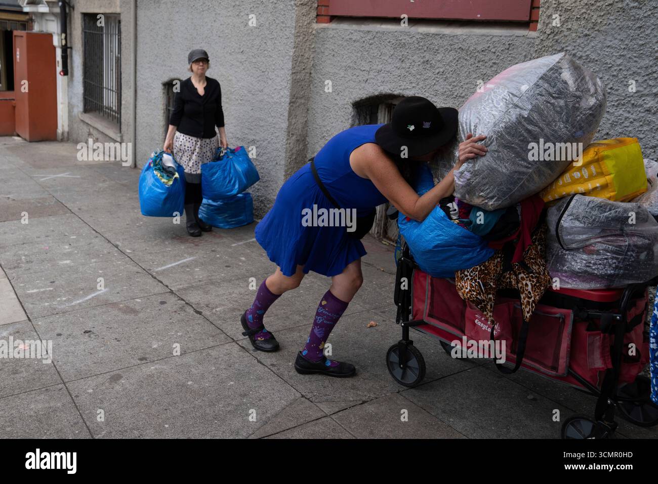 Kate Haas, left, watches as attendees of a clothing swap push items ...