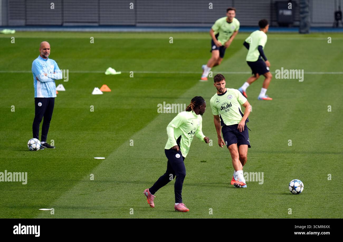 Manchester City manager Pep Guardiola (left) looks on as players train ...