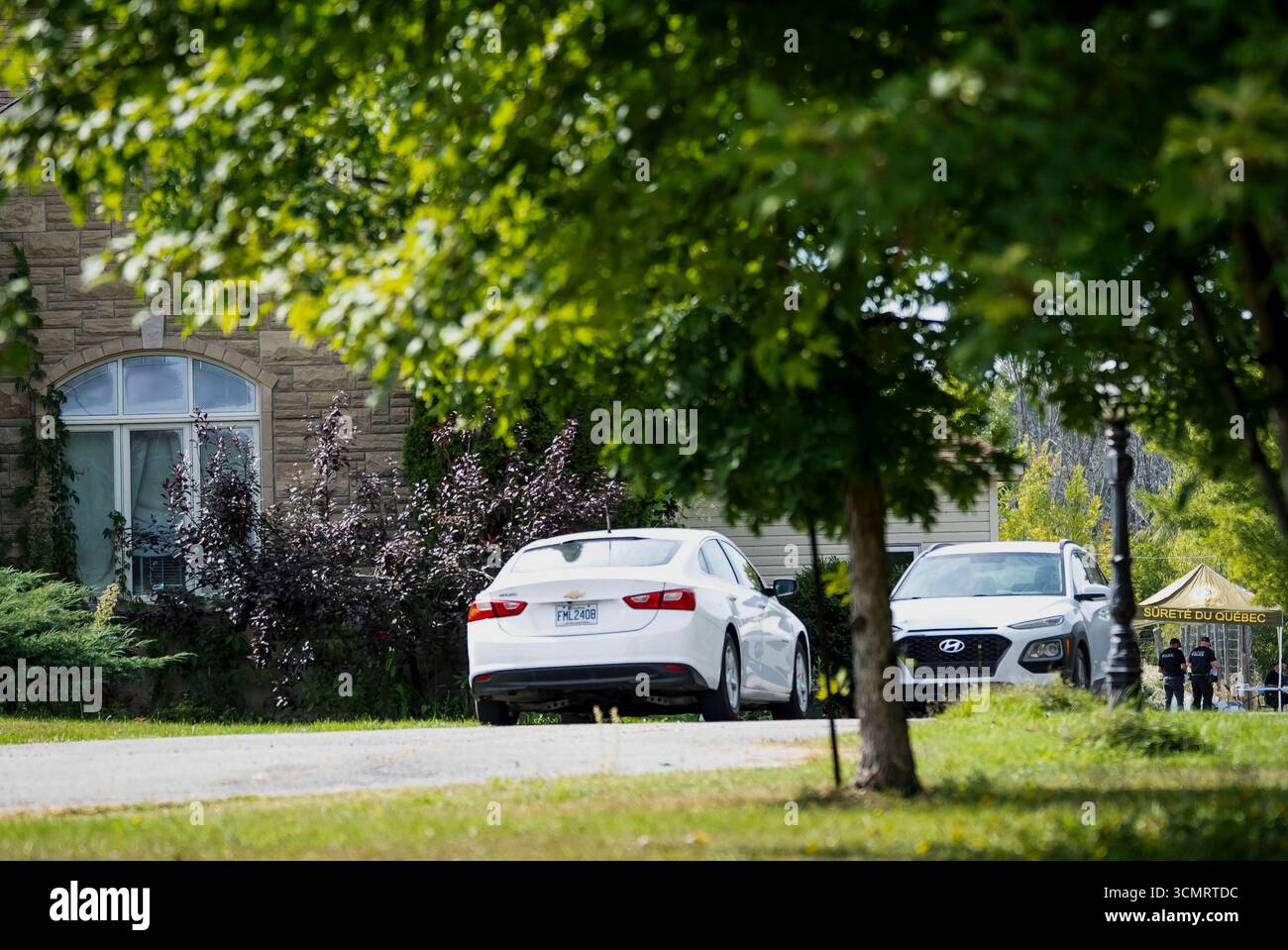 Police are seen at a house during an operation in Vaudreuil-Dorion, Que ...