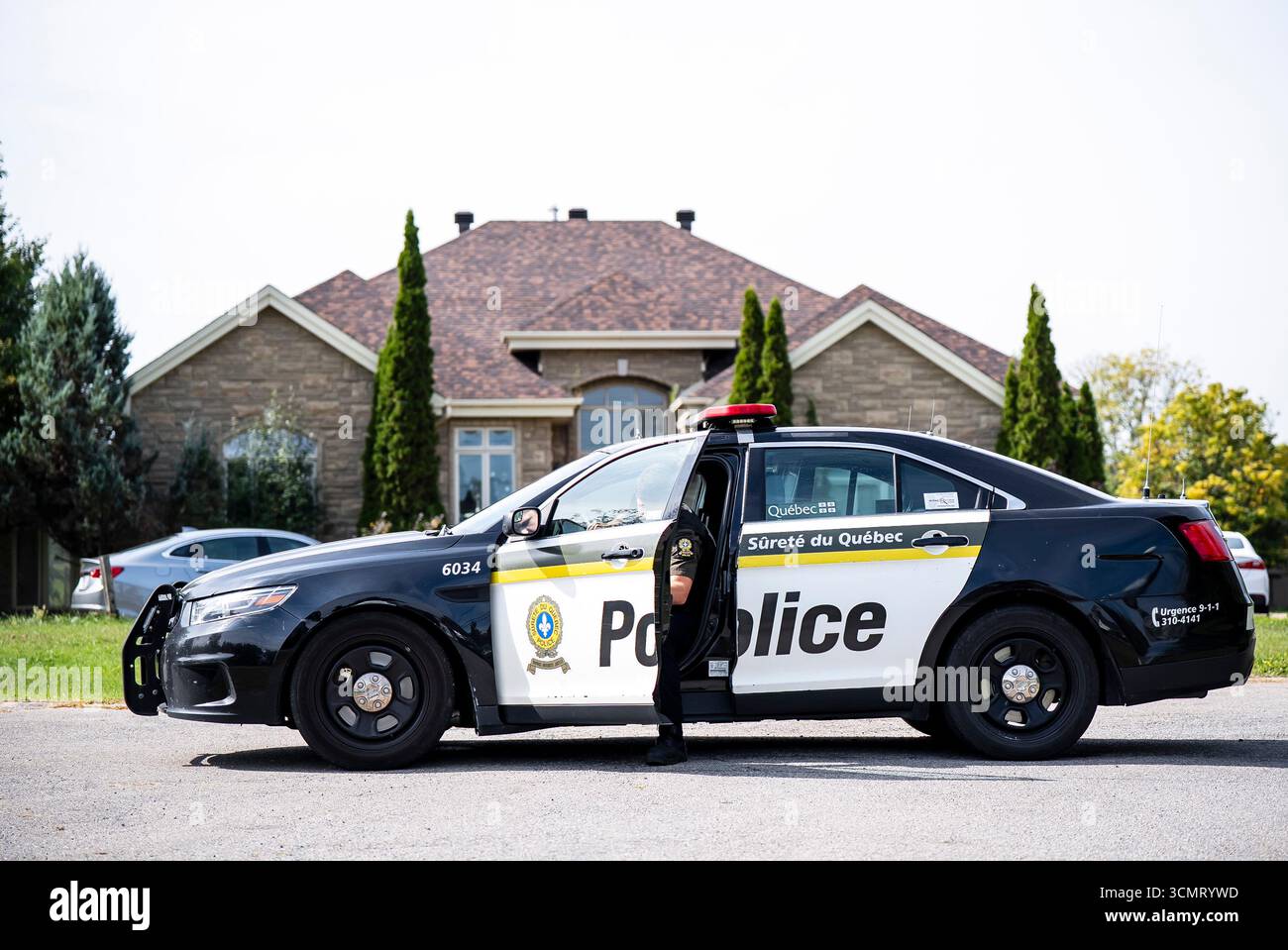 Police are seen at a house during an operation in Vaudreuil-Dorion, Que ...