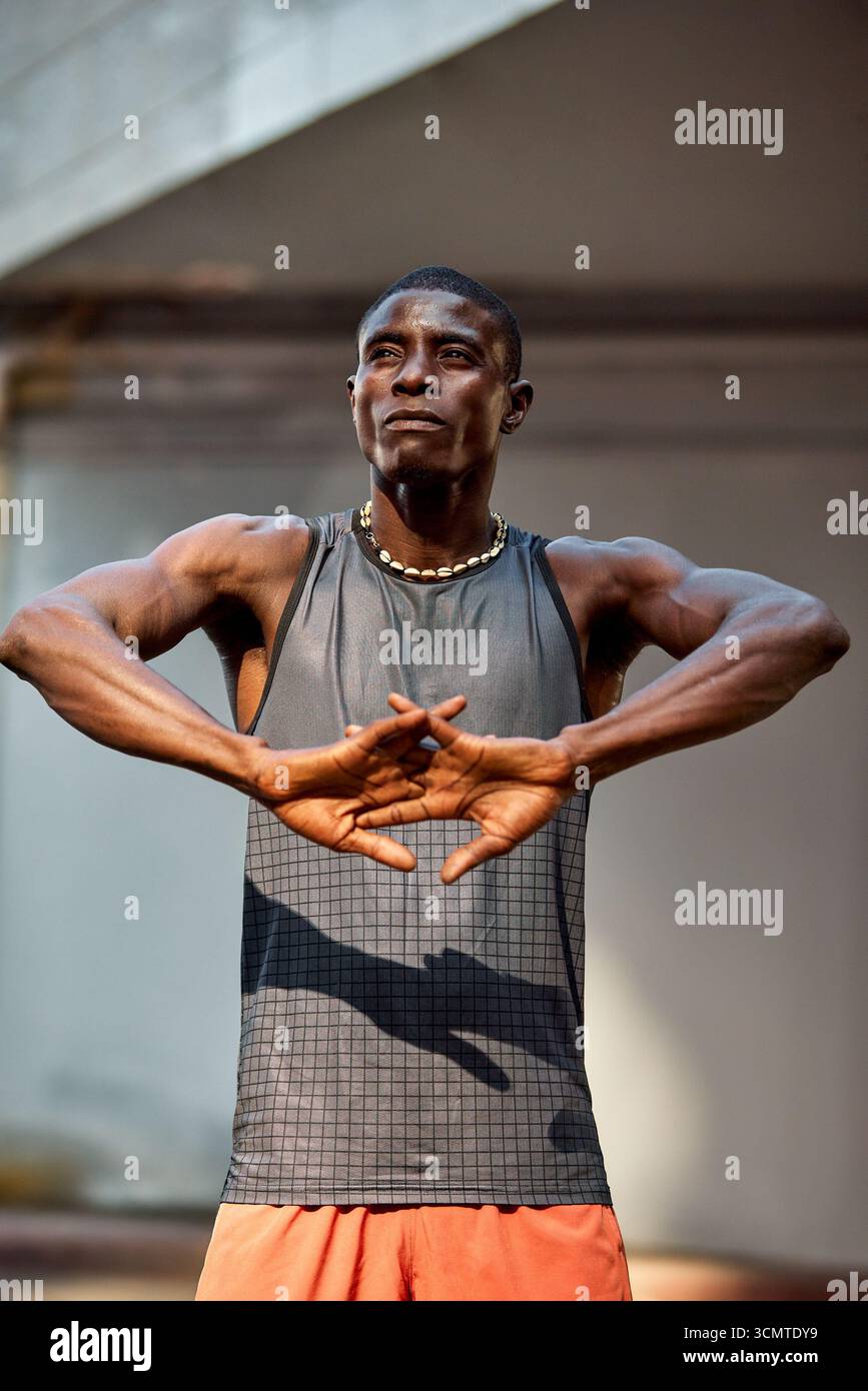 An athlete prepares for an intense workout session by performing arm ...