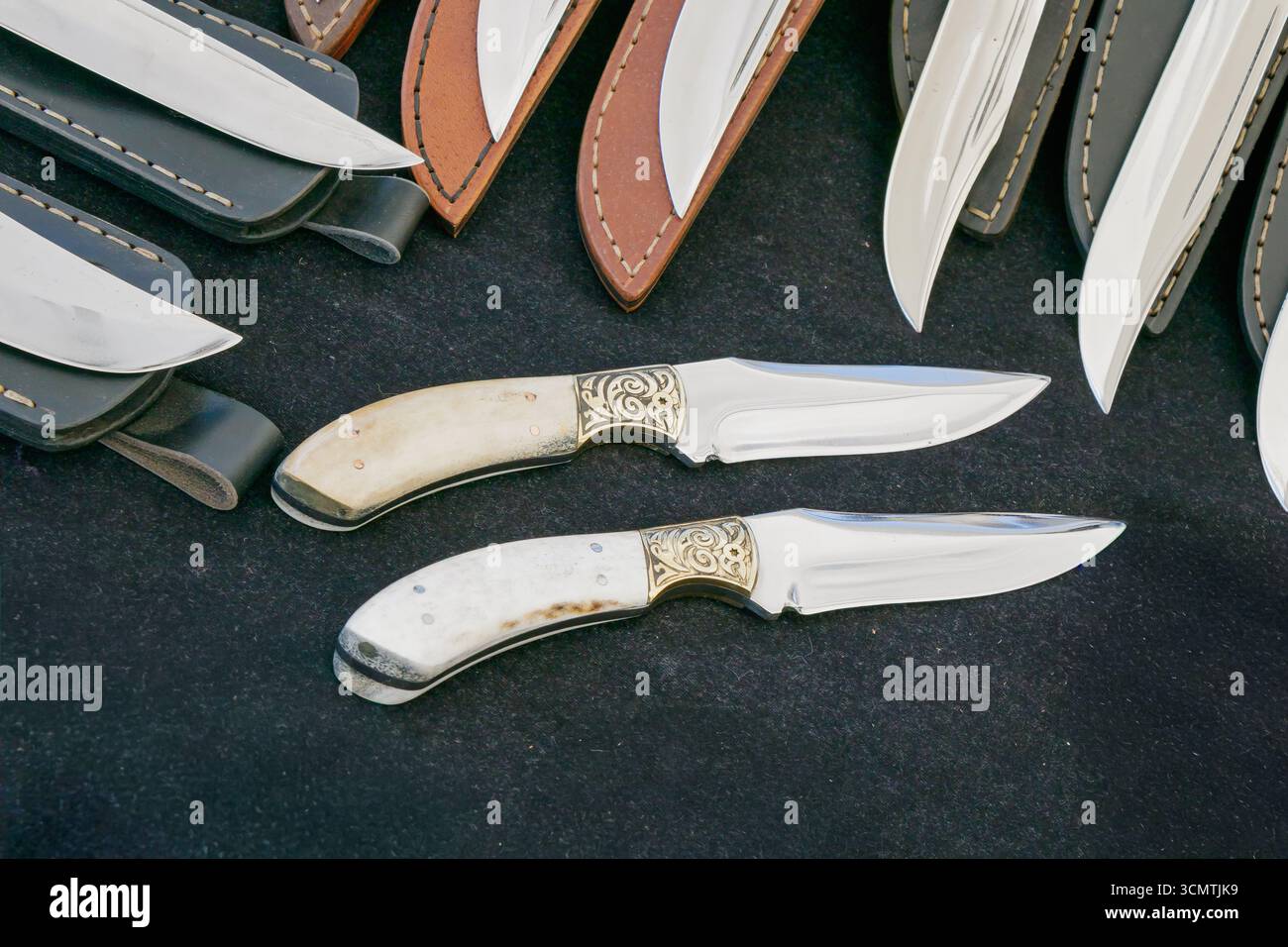 Close-up of two handmade knives with shiny steel blades and ornate ...