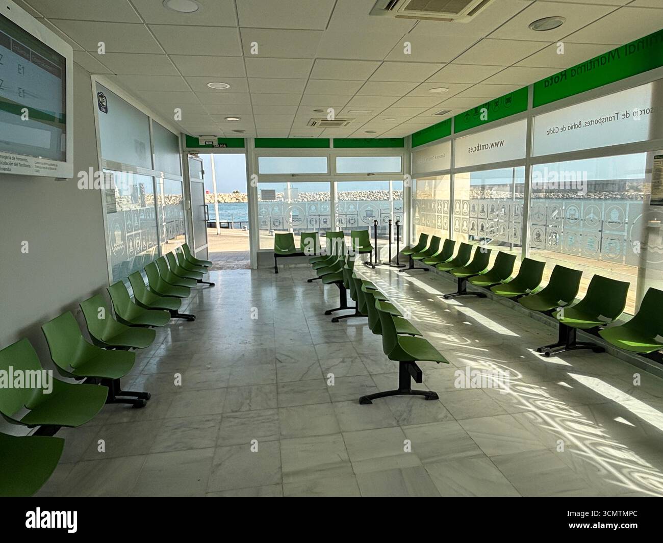 Large ferry terminal in Spain showing check-in desks, benches and ...