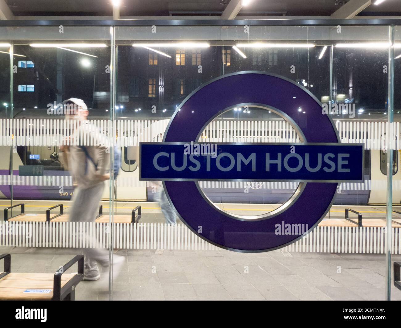 A man passes along a glass partition featuring the purple Elizabeth ...