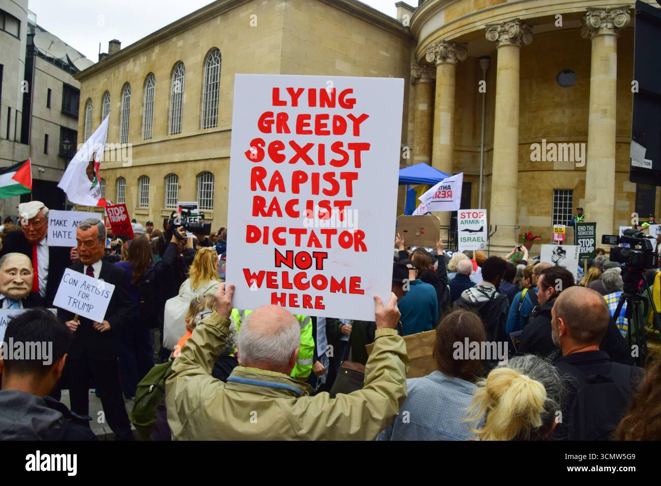 A protester holds a placard making his feelings known about Trump ...