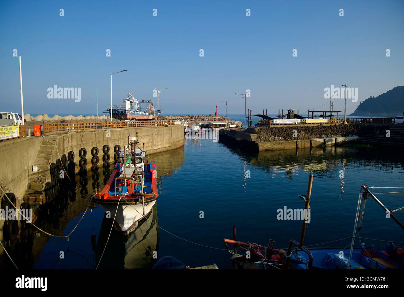 Fishing boats moor inside the narrow entrance of a Seogwipo harbor as ...