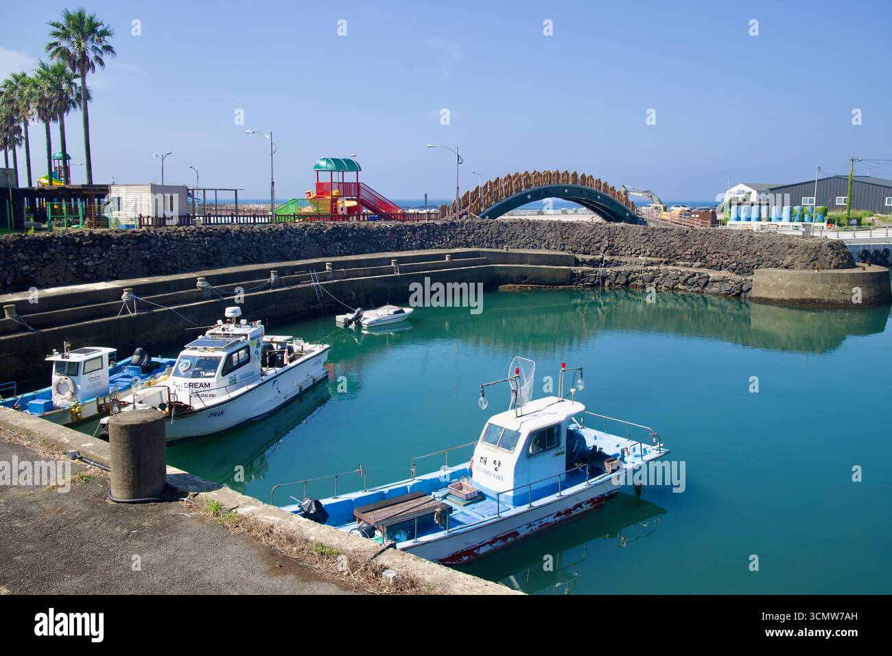 Namwon Port’s inner basin shows moored fishing boats below a low arched ...