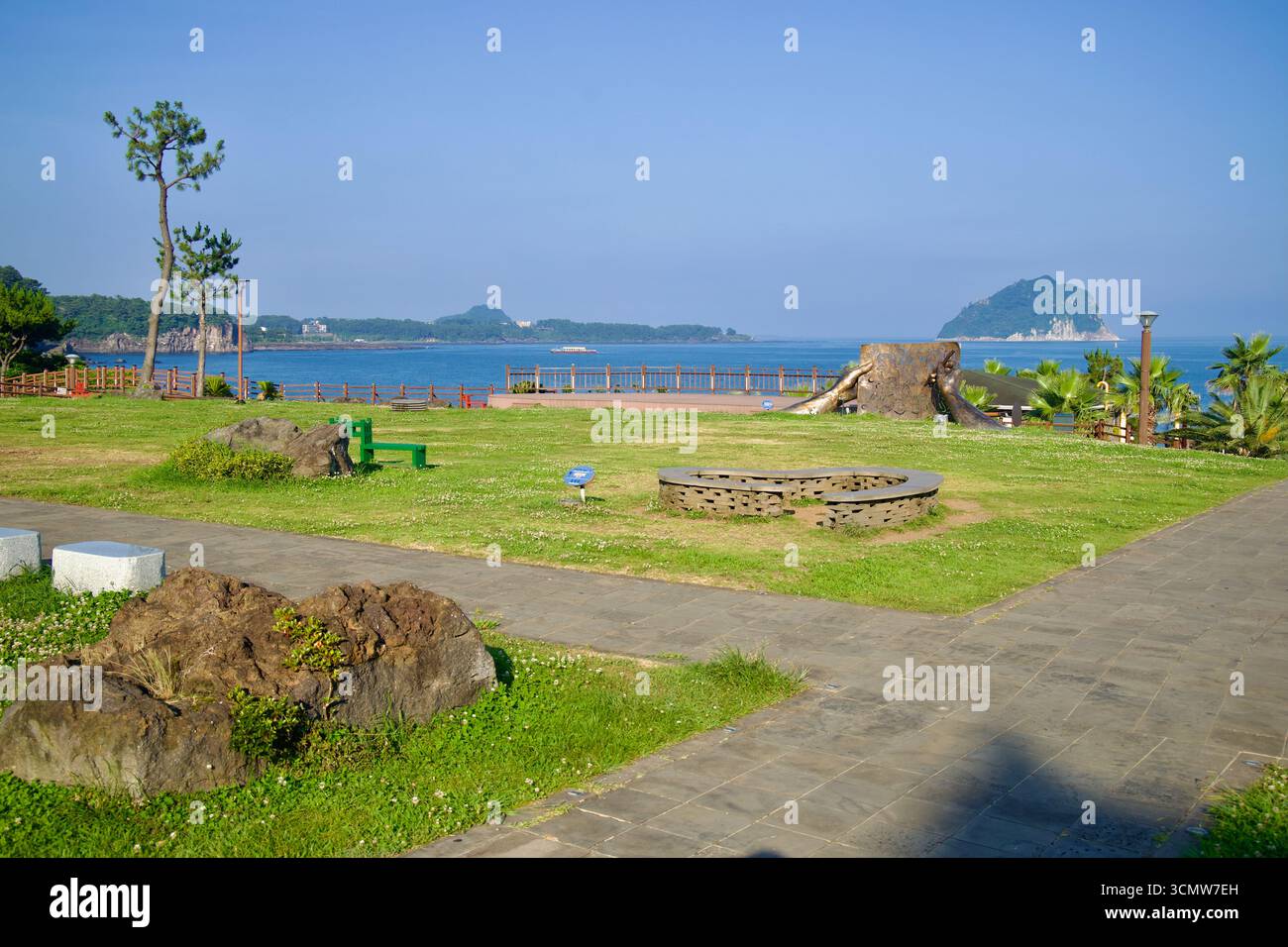 An open lawn with benches, stone paths, and public art in Jaguri ...