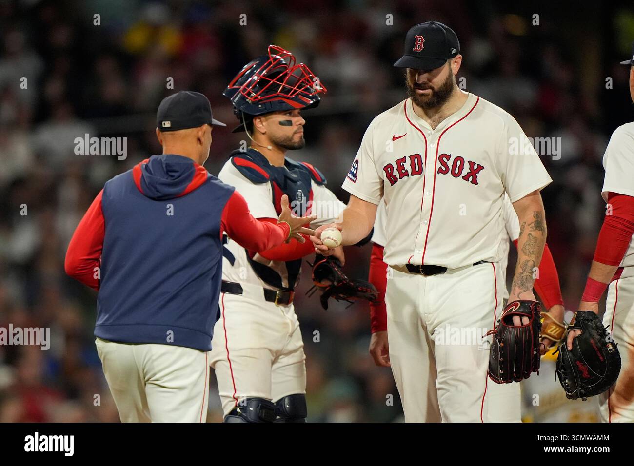 Boston Red Sox starting pitcher Lucas Giolito hands over the ball after being pulled in the ...
