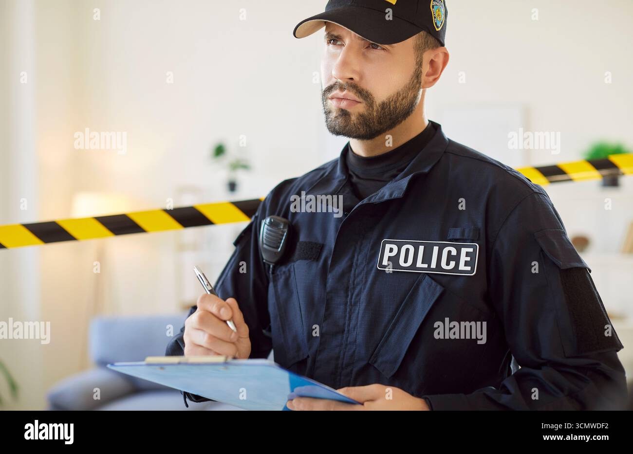 Police officer is actively engaged in documenting information at crime ...