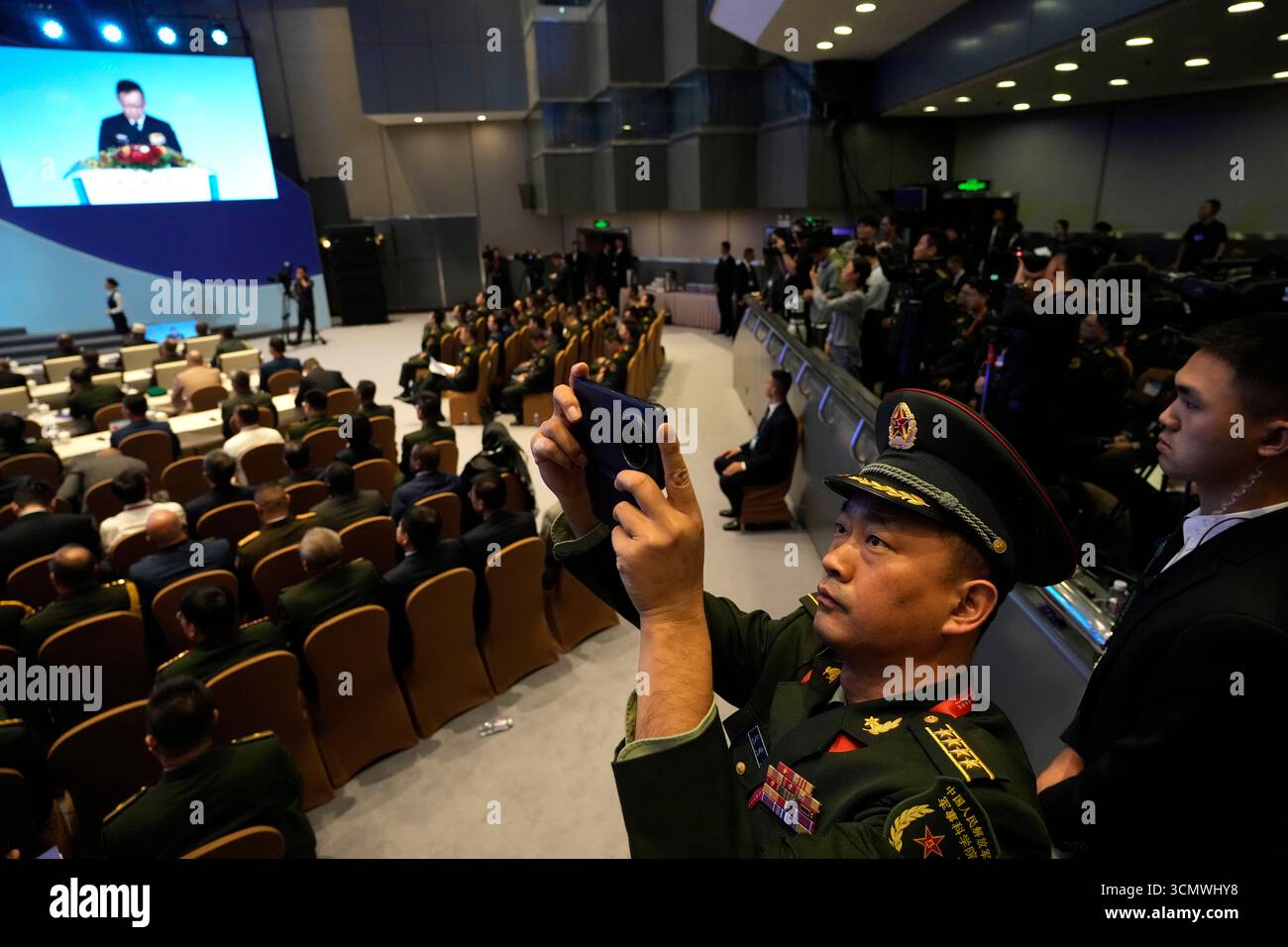 A Chinese military officer uses his phone to record as Chinese Defense ...