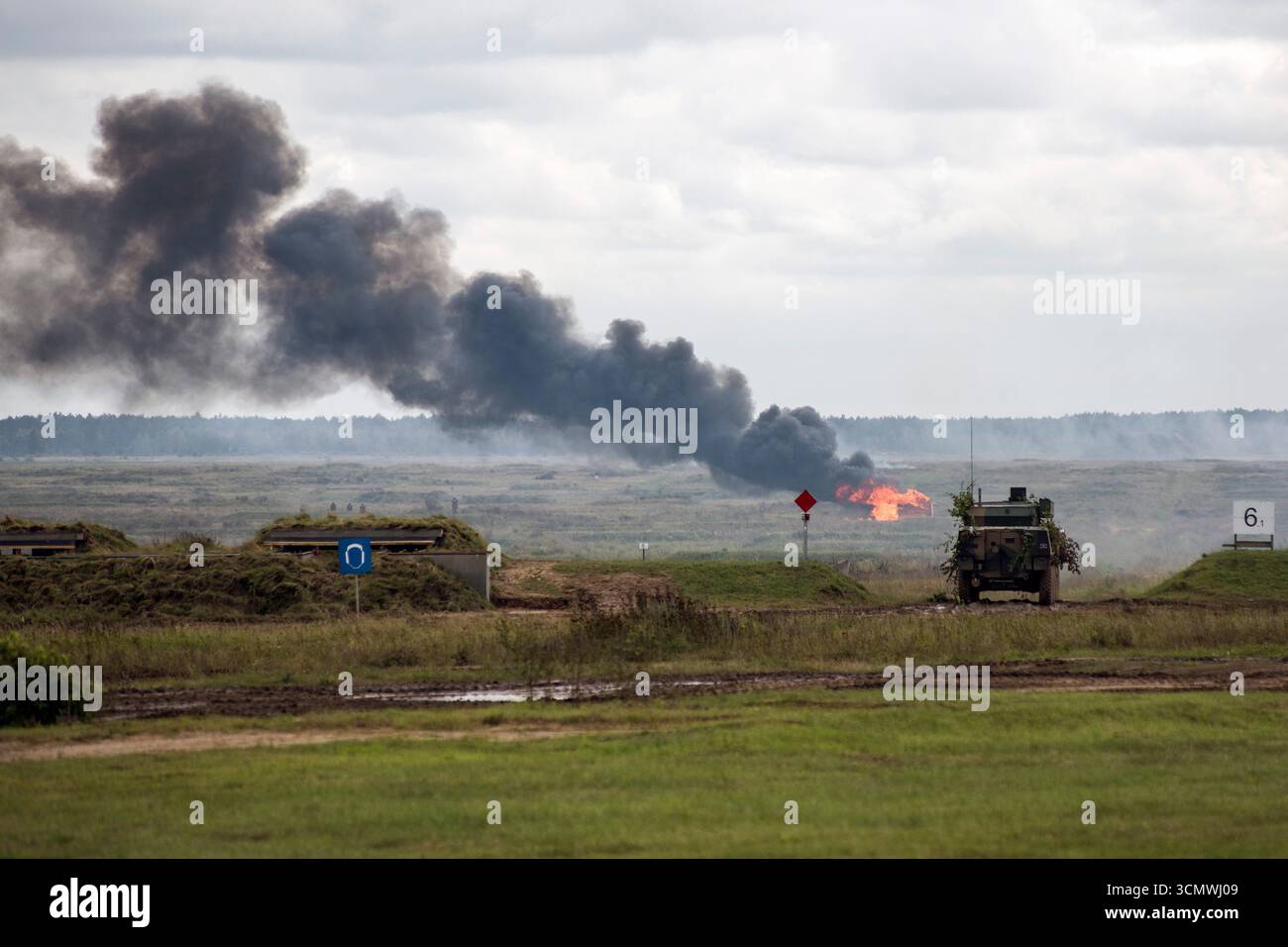 A cloud of smoke and fire rises over the field during military ...