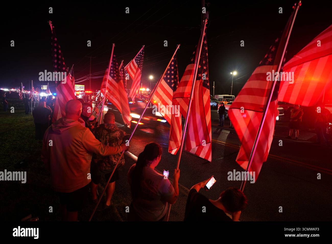 People hold American flags during a procession Wednesday, Sept. 17 ...