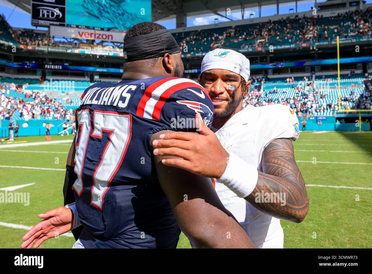 Miami Dolphins quarterback Tua Tagovailoa (1) hugs New England Patriots ...
