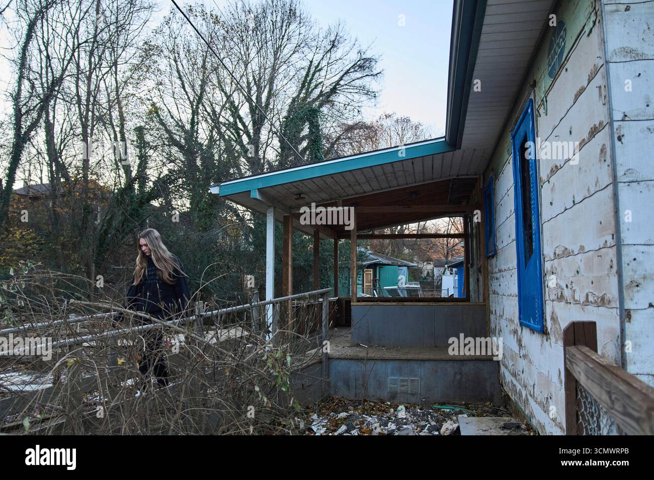 Natalie Briggs walks down the back ramp of her home that was damaged ...