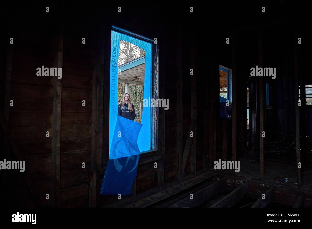 Natalie Briggs looks through a window of her home that was damaged ...