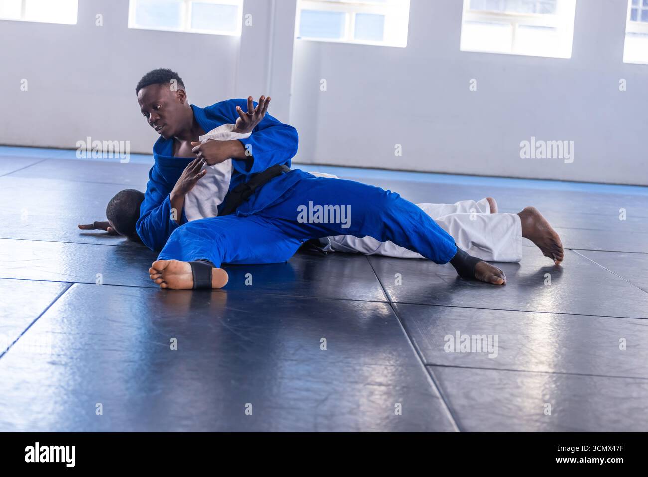 African american male training partners practicing ground grappling on ...