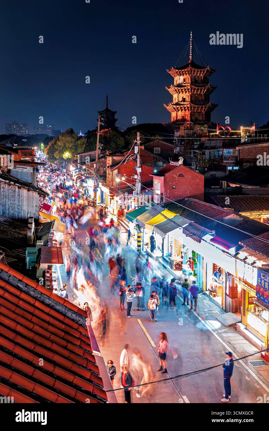 Busy pedestrian street with the twin pagodas of Kaiyuan Temple ...