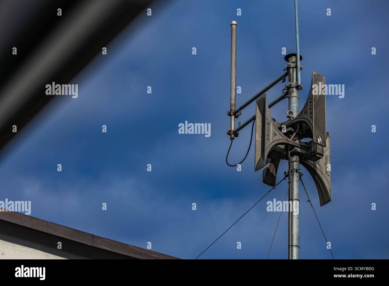 An alarm siren mounted on the roof of a building, the siren emits a ...