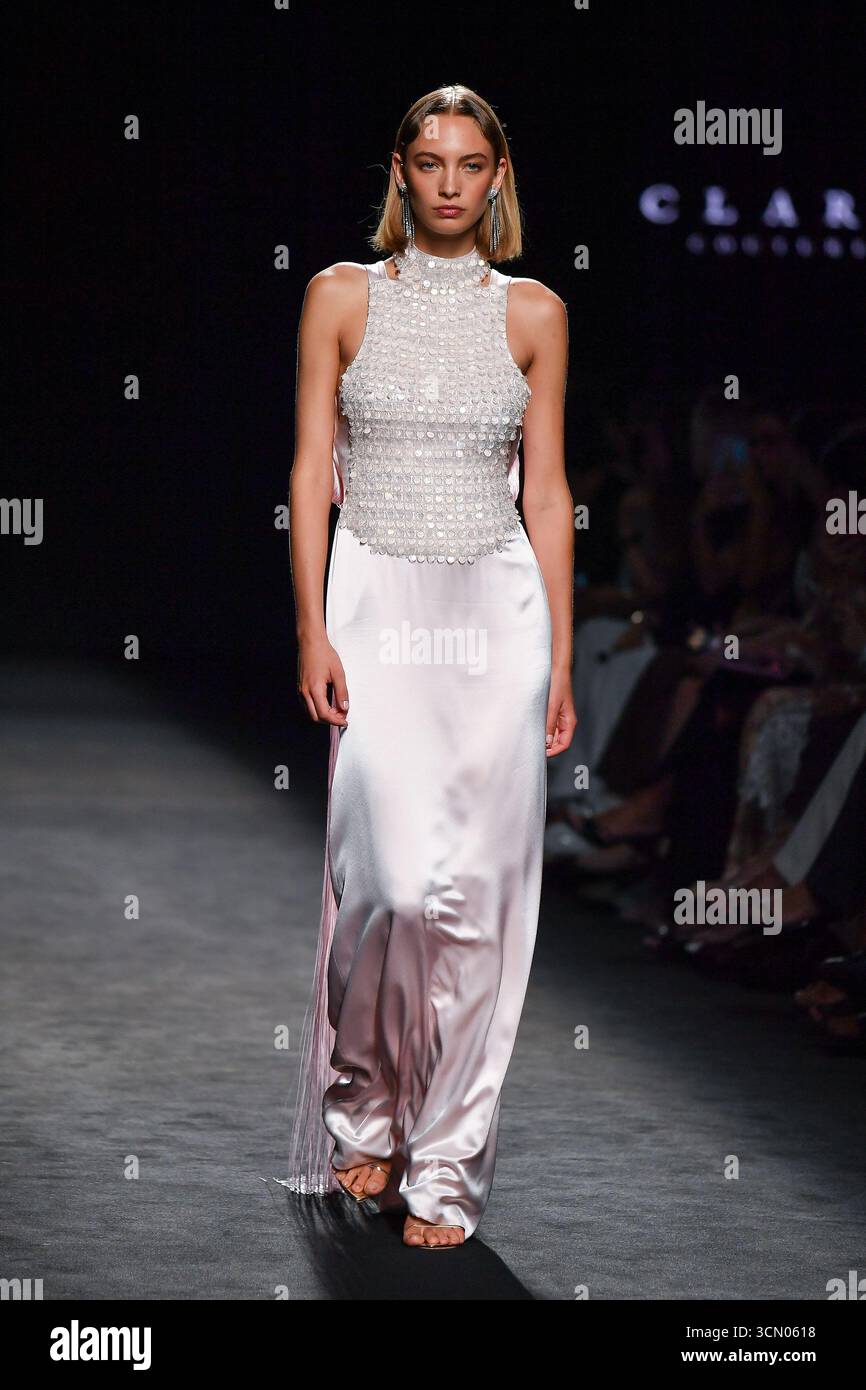 A model walks the runway wearing a design by Claro Couture during ...
