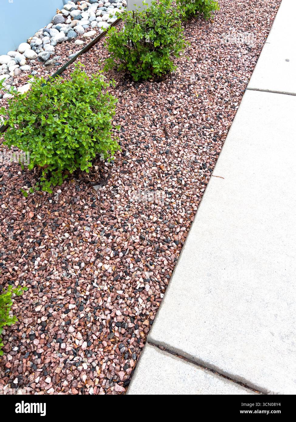 Landscape Edging with River Rocks and Red Gravel Stock Photo - Alamy